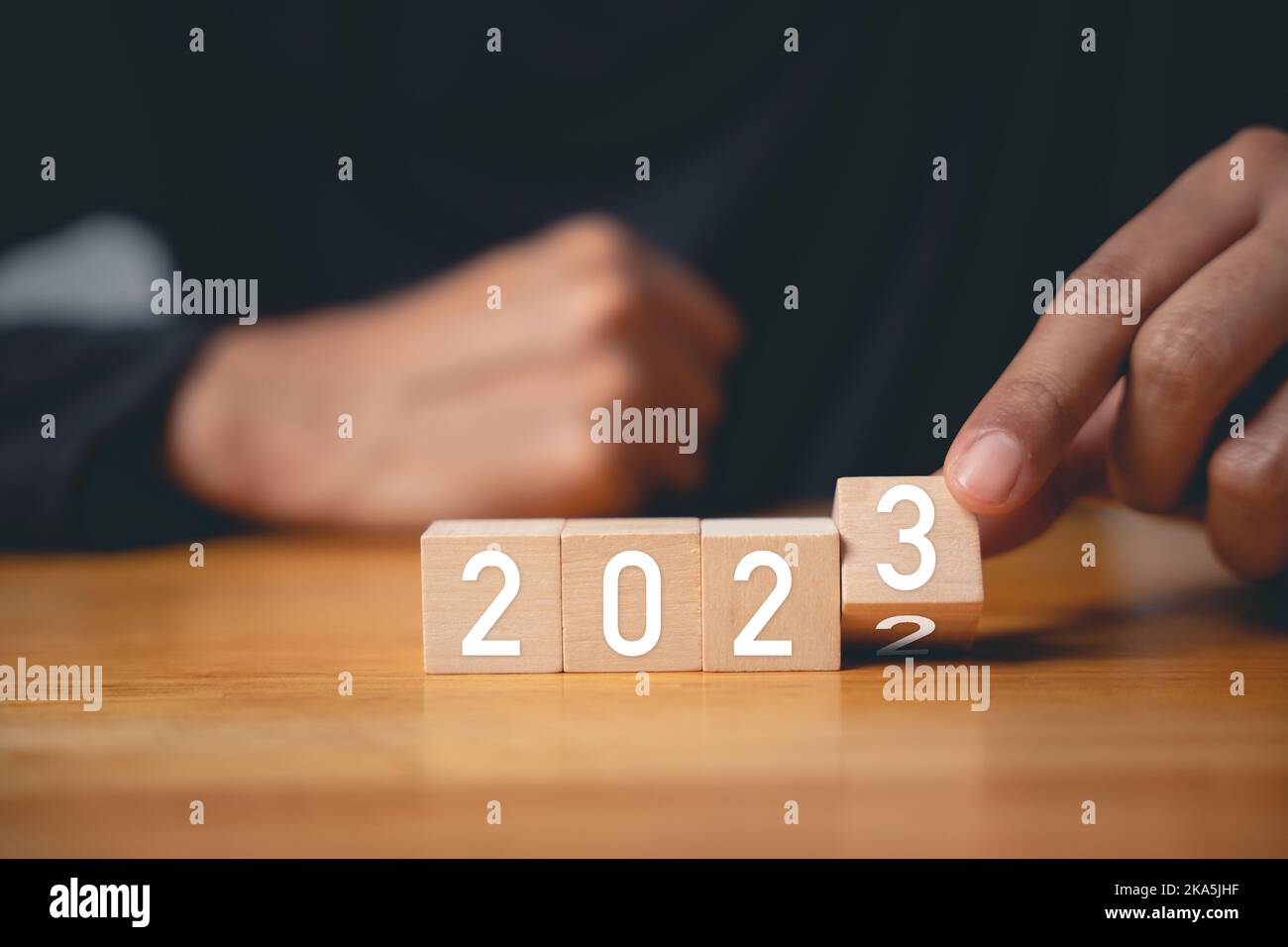 Businessman flips wood cubes block number 2 to 3 for new years 2023 ...