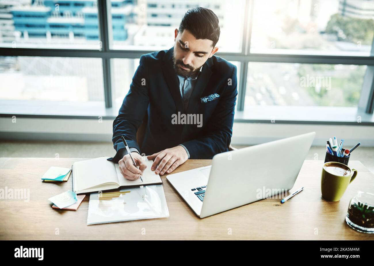 Knocking those work tasks out of the park. a young businessman writing ...