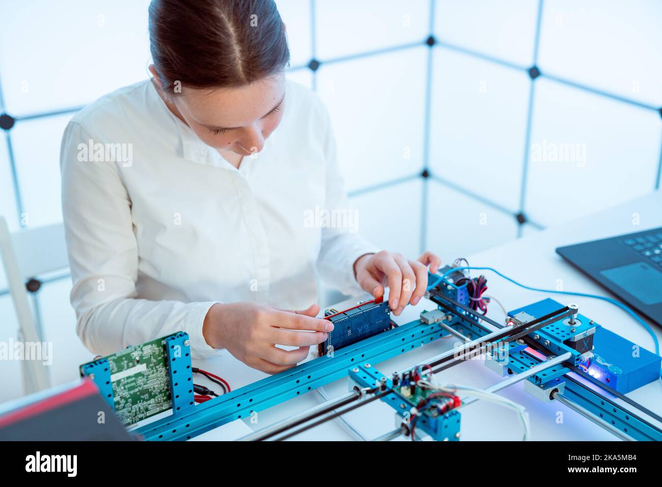 female student sets up a laser cnc plotter at the University robotics ...