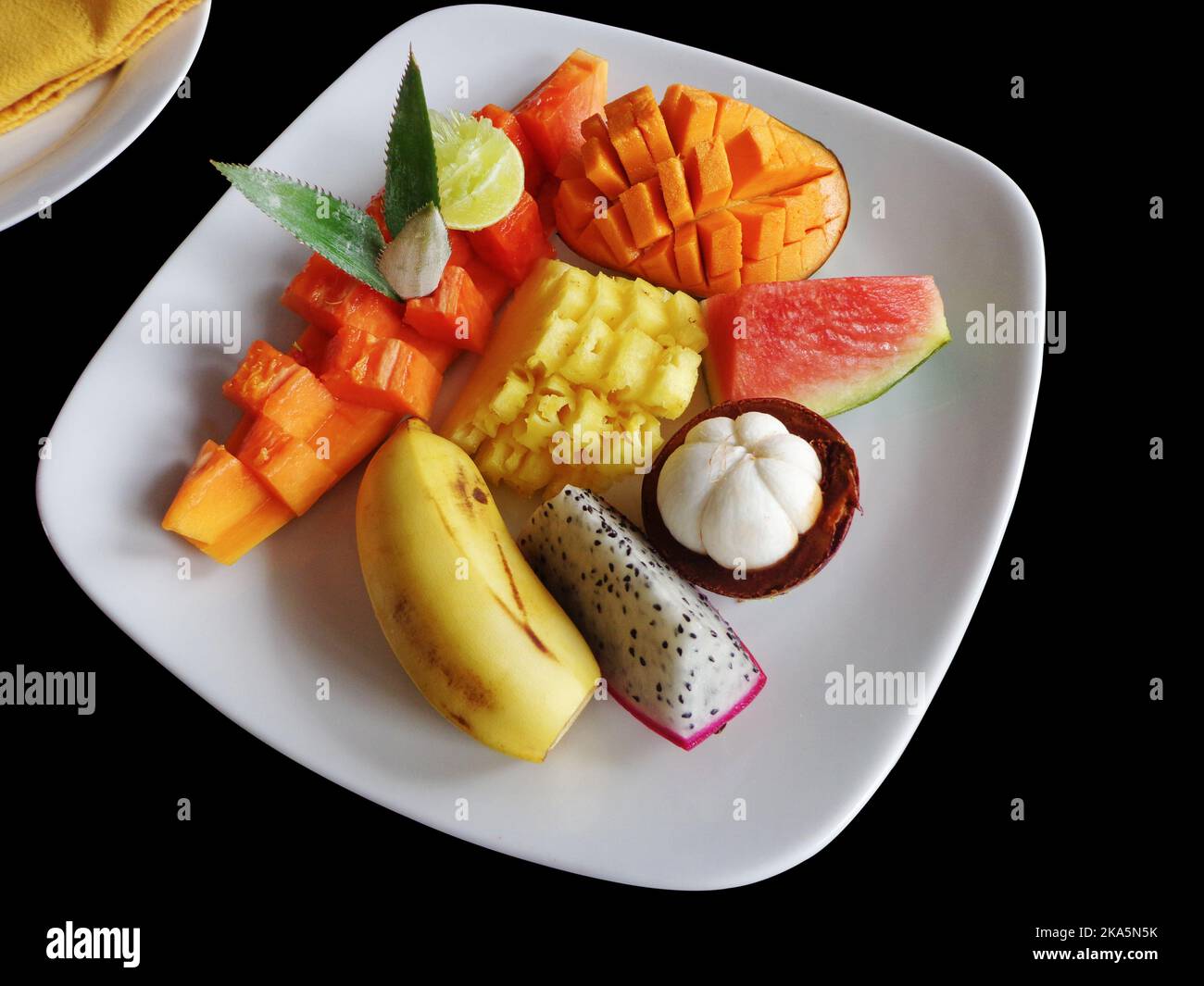 Tropical colorful fresh fruit plate with mango, banana, papaya ...