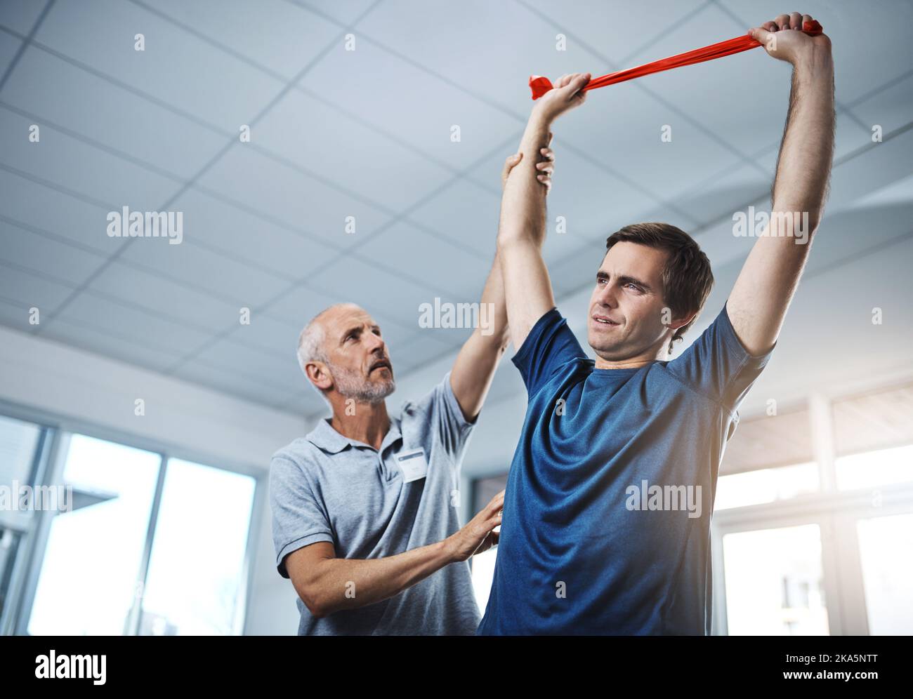 Try to relax your shoulders a bit. a physiotherapist helping a patient ...