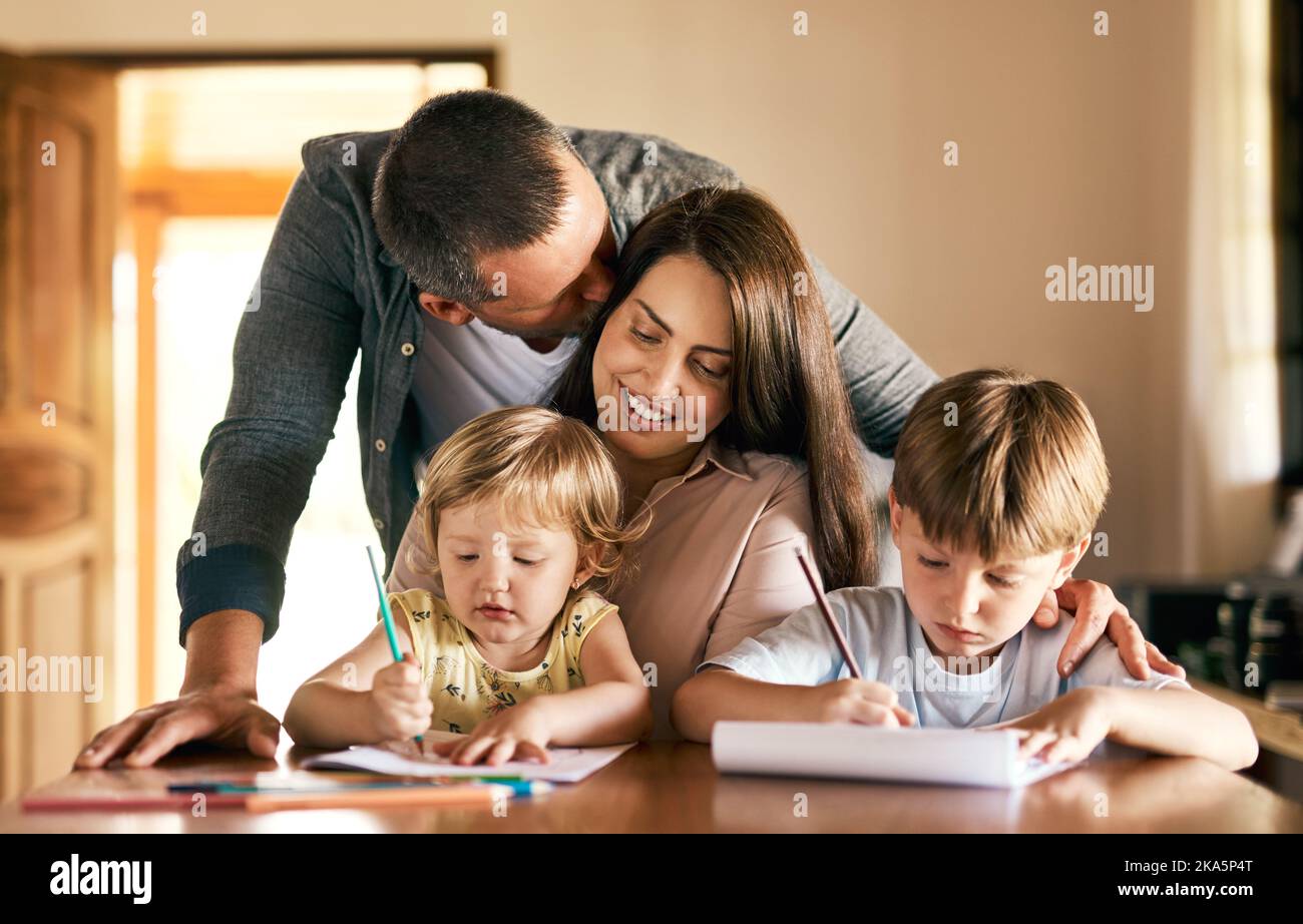 Kids were born to be creative. a young family of four drawing and getting creative together at ...