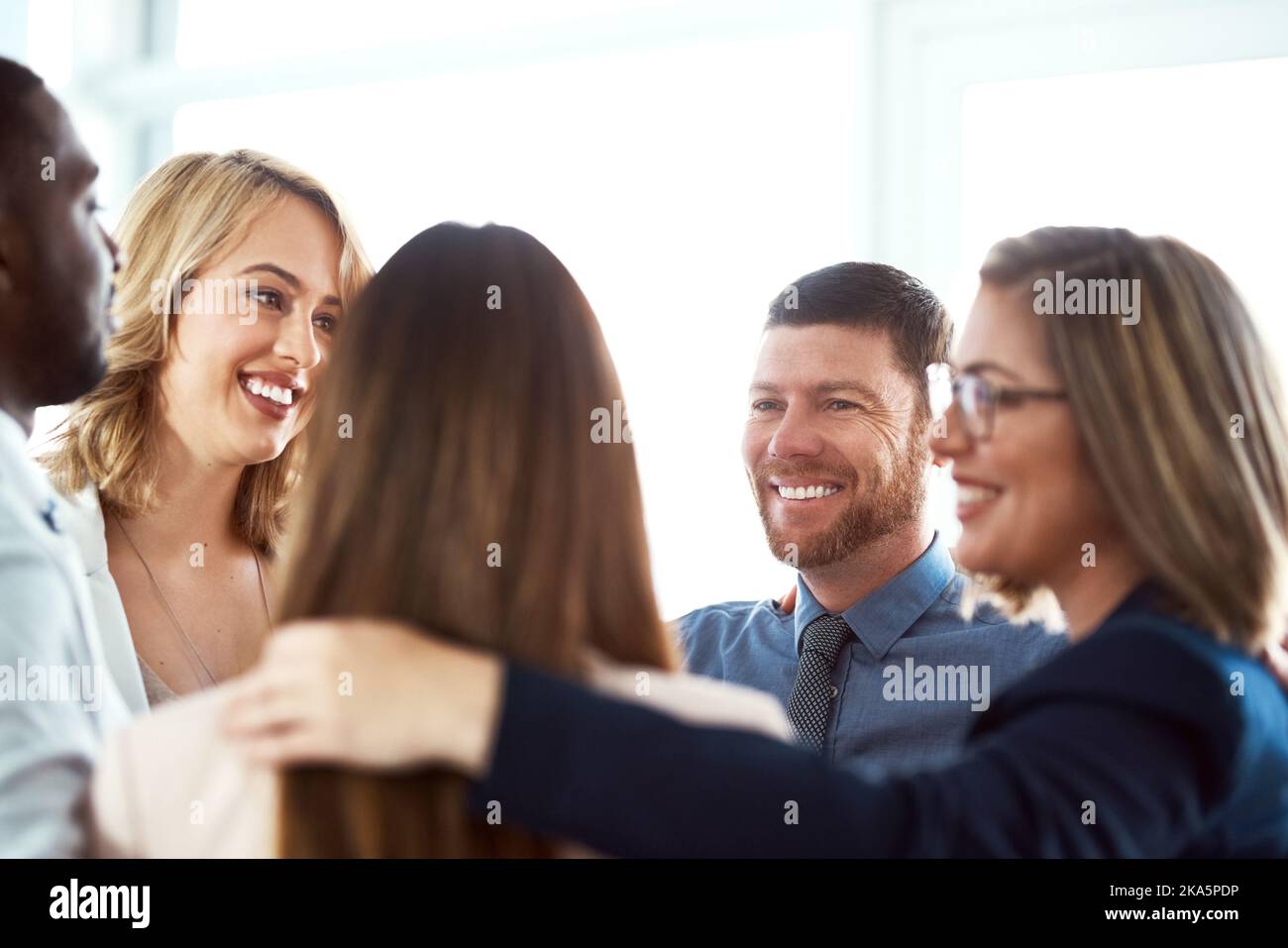 Lets get together. a group of work colleagues forming a huddle together ...