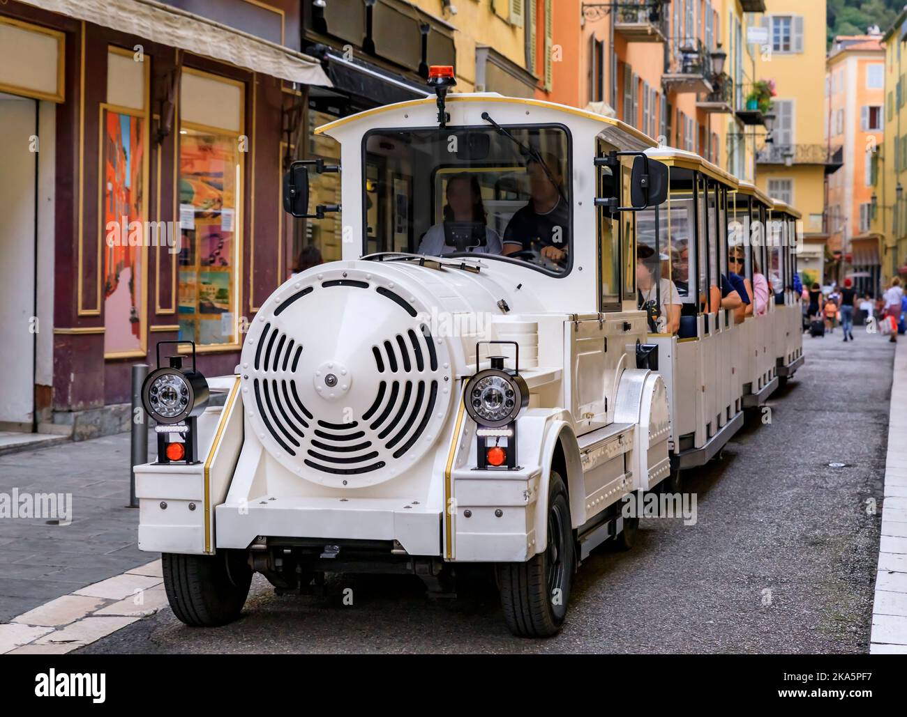 White tourist train driving through the narrow streets in the Old Town ...
