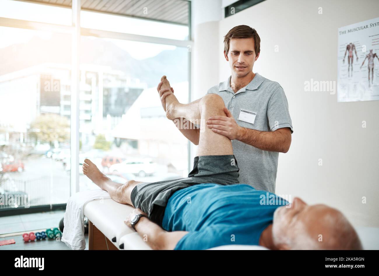 Make sure to exercise this leg everyday. a young male physiotherapist ...