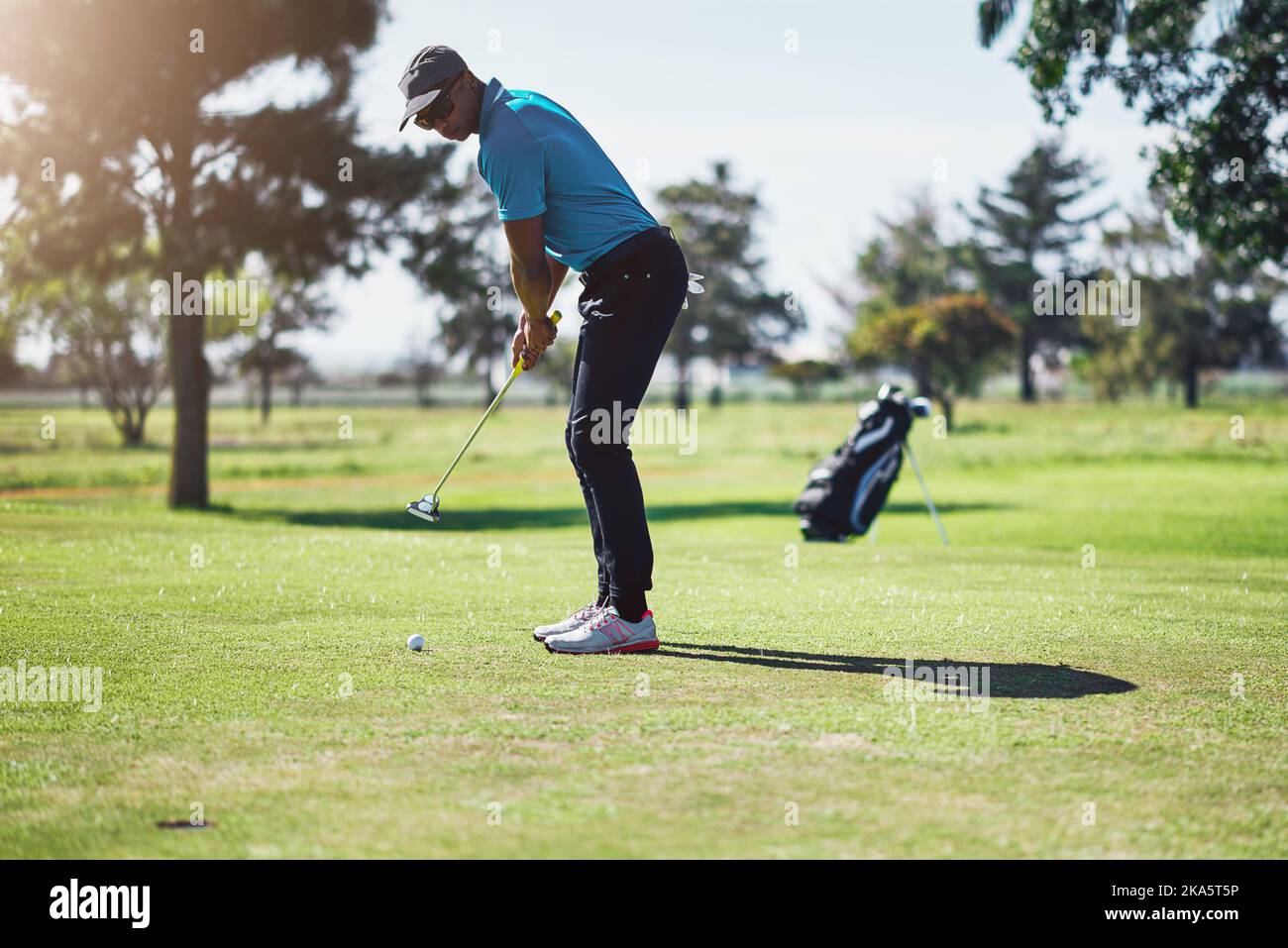 My turn to show off my skills. a focused young male golfer about to ...