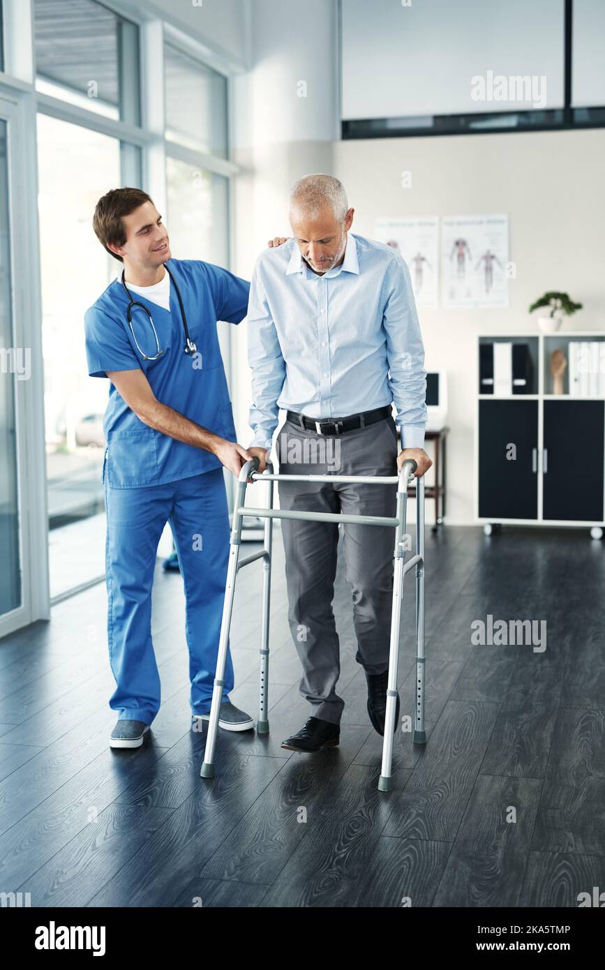 Making steady progress towards a full recovery. a male nurse assisting ...