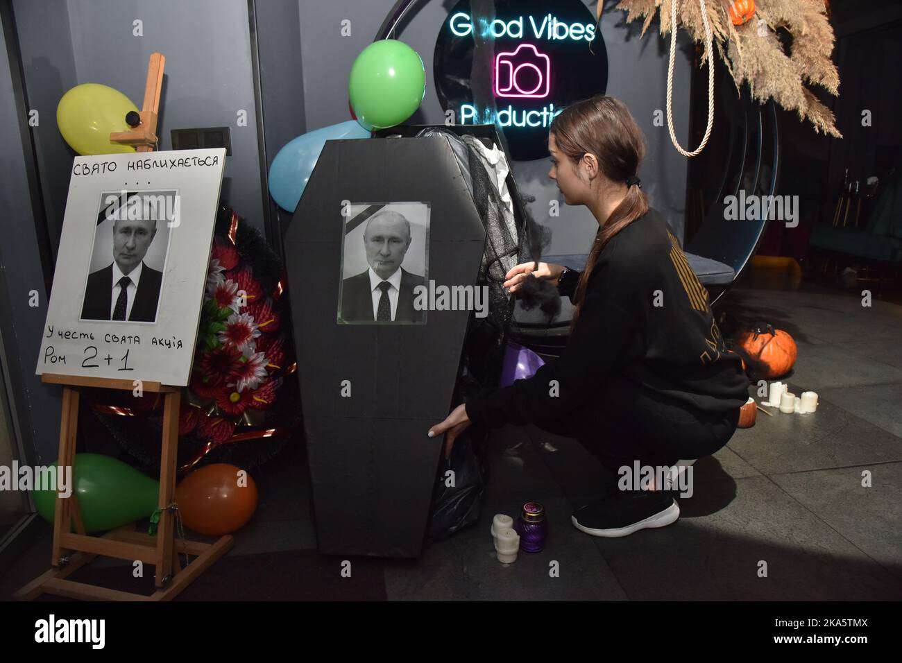 A girl examines a coffin with a portrait of Russian President Vladimir ...