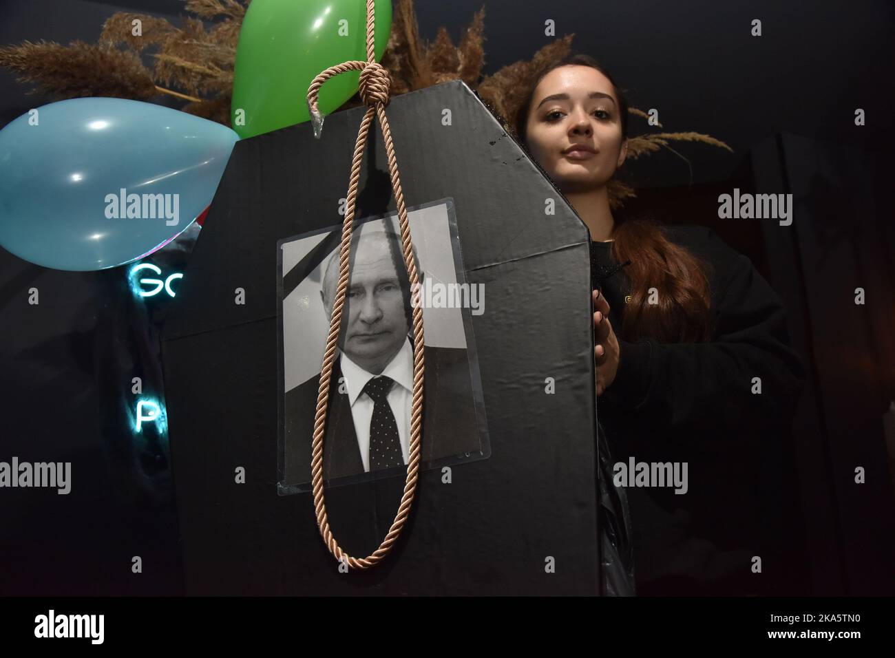 A girl holds a coffin with a portrait of Russian President Vladimir ...