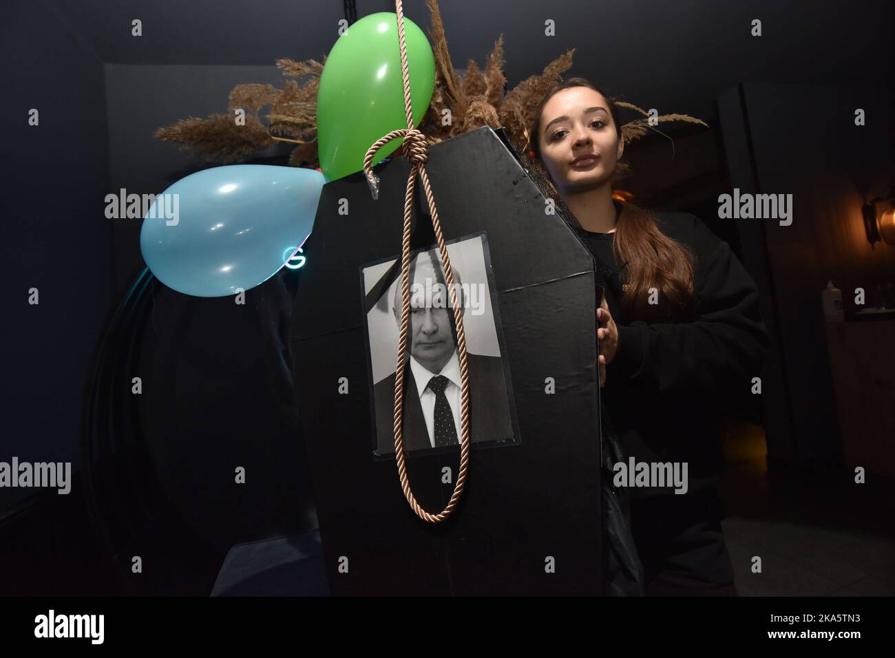 A girl holds a coffin with a portrait of Russian President Vladimir ...