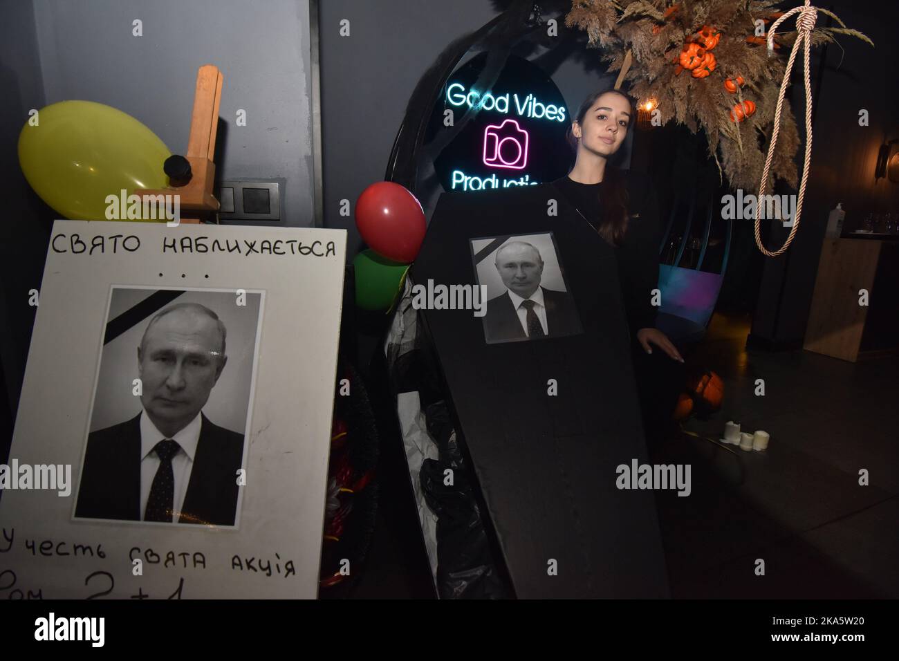 Lviv, Ukraine. 31st Oct, 2022. A girl poses with a coffin on which a ...