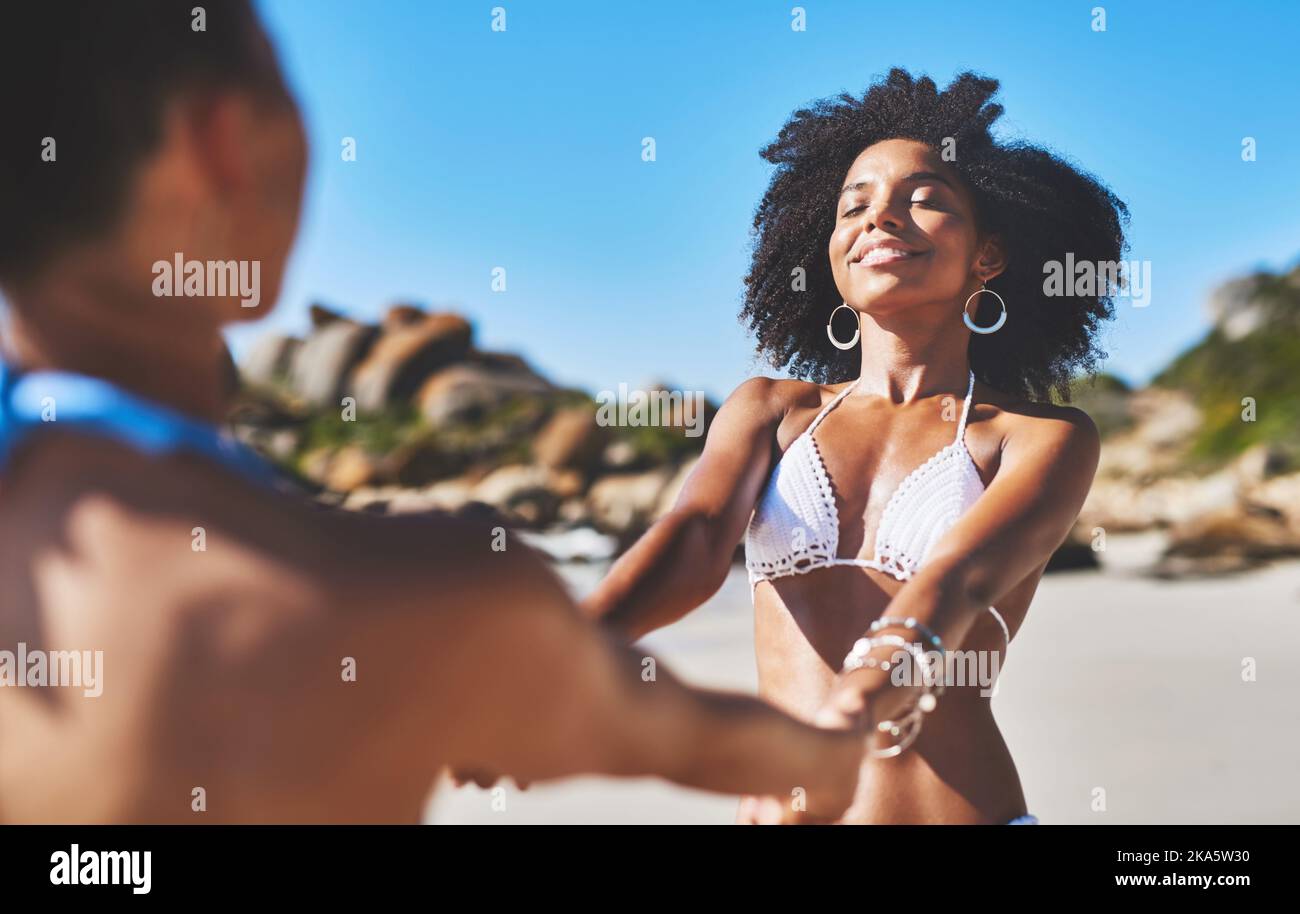 Hold onto those happy days. two young women enjoying a playful moment on the beach Stock Photo ...