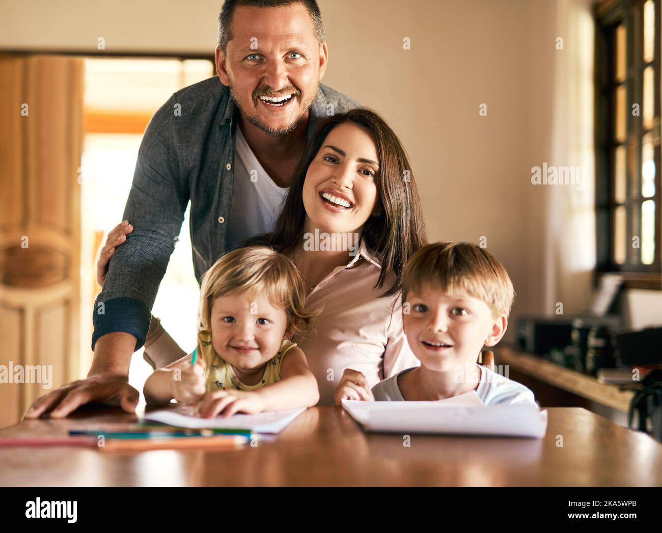 Learning is a family affair. a young family of four drawing and getting ...