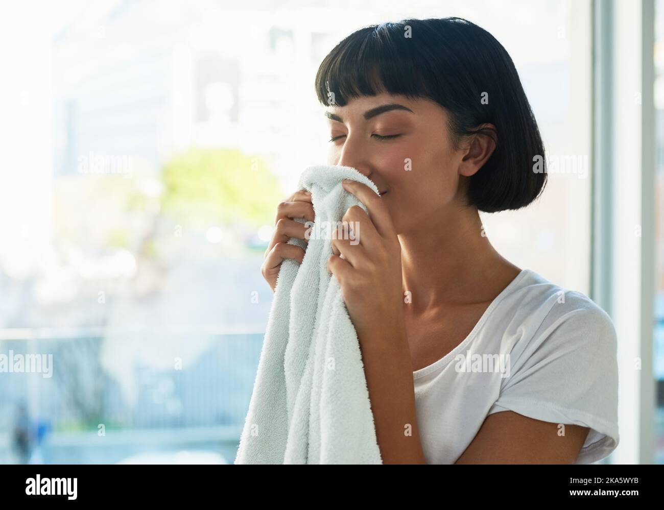 That fresh laundry smell is worth it. a young woman smelling freshly ...