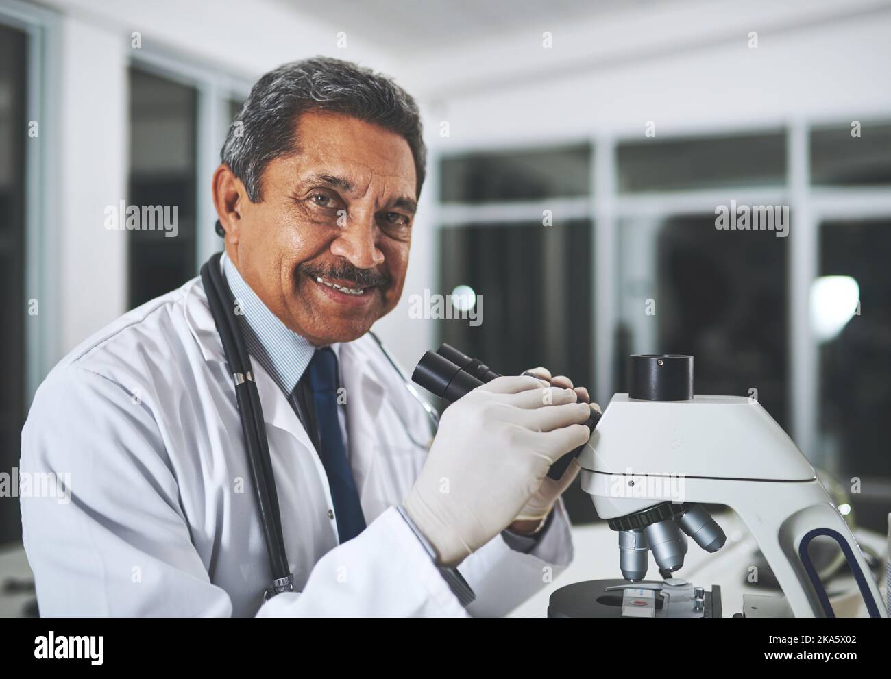 Doctor using a microscope hi-res stock photography and images - Alamy