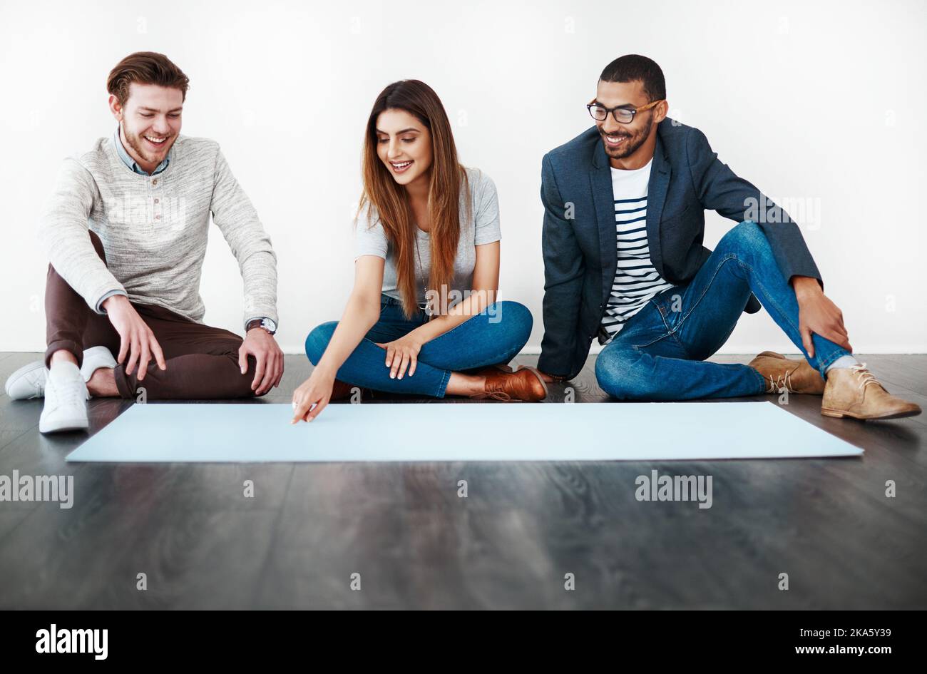 Teamwork from conception to action. Studio shot of a group of young ...