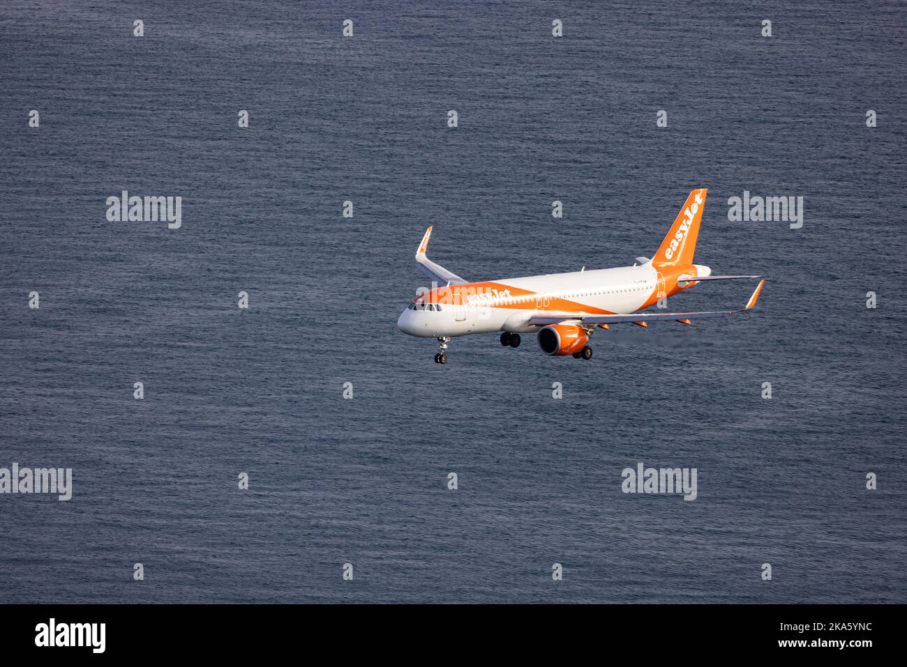 EasyJet Airplane landing to the airport during sunny morning. Aerial ...