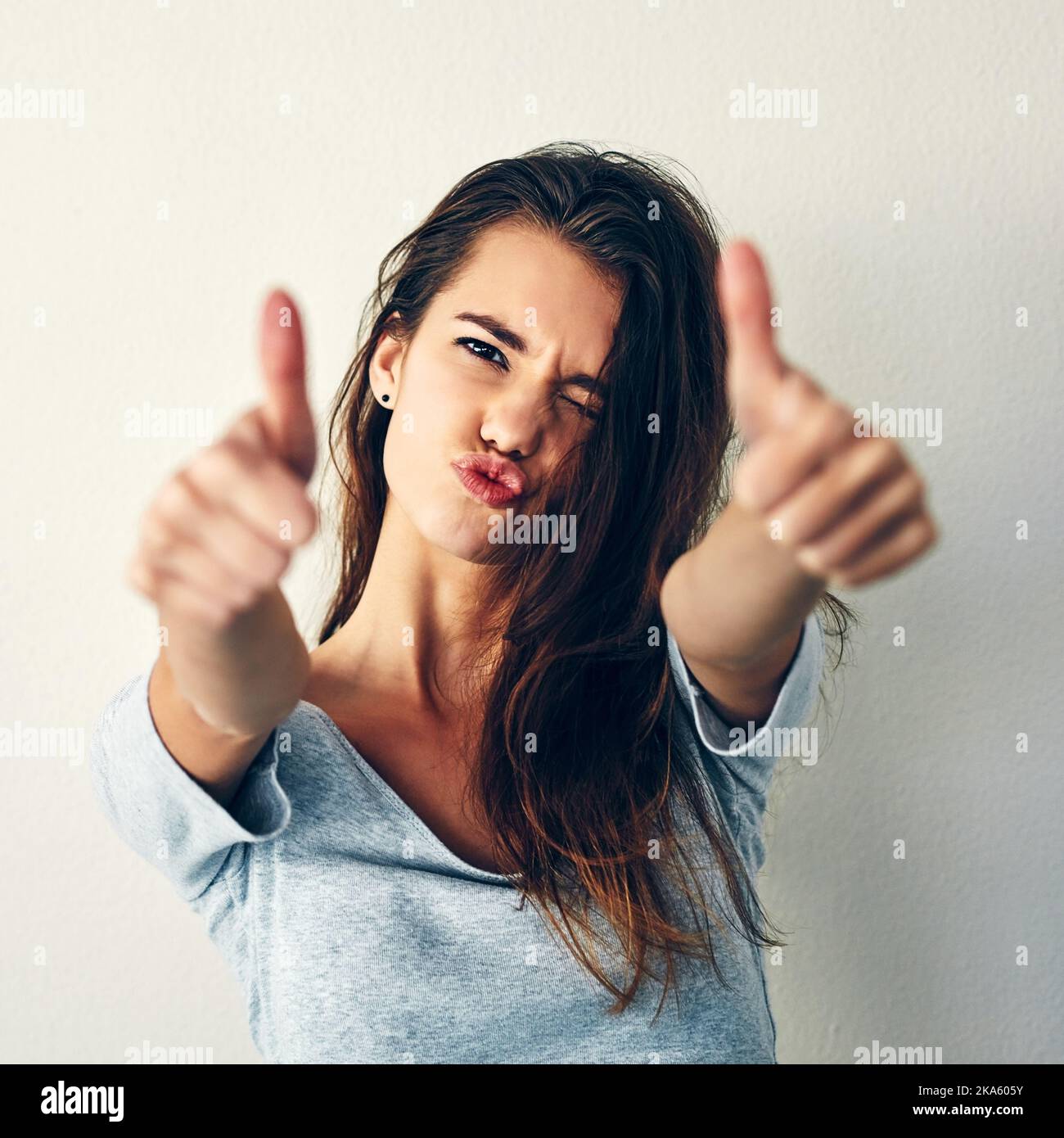 Ill give you double thumbs up. Studio shot of an attractive young woman ...