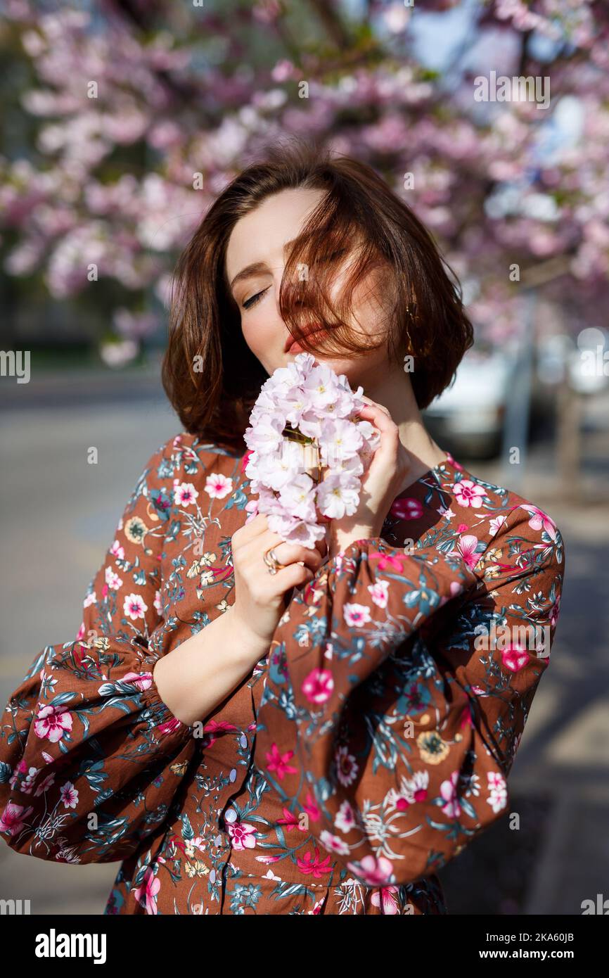 A spectacular woman in a bright dress stands against the background of ...
