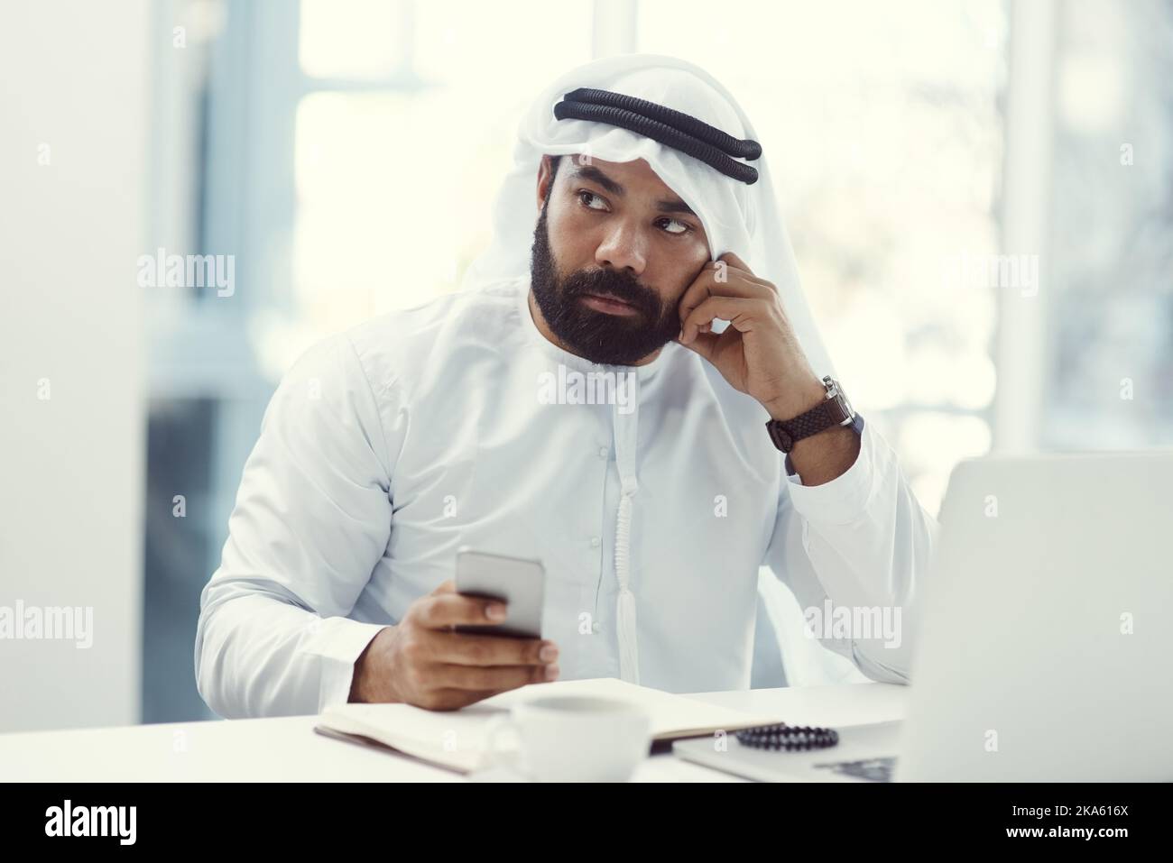 Thinking it over. a young businessman dressed in Islamic traditional ...