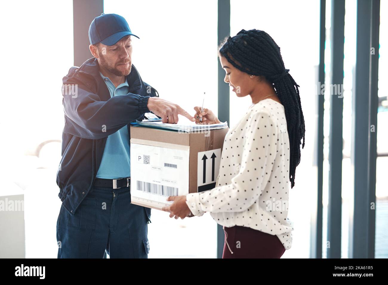 Please make sure you sign over there. a handsome delivery man getting a ...