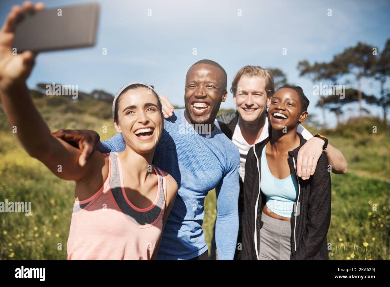 Our friendship will motivate others. a group of friends taking a selfie outdoors after their ...