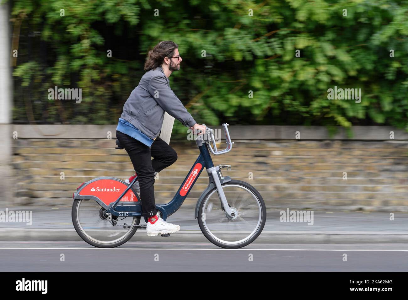 A male cyclist riding a Transport for London, Santander Cycles hire bicycle, commonly known as a ...