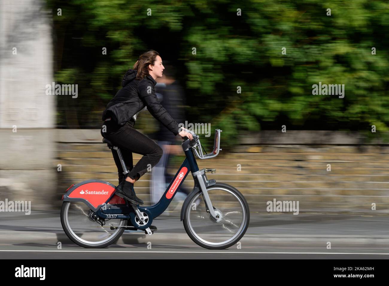 A female cyclist riding a Transport for London Santander Cycles, hire ...