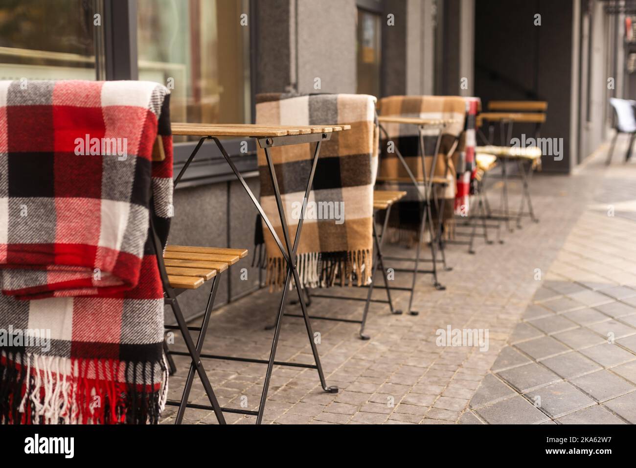 comfy seats in a street cafe with blankets Stock Photo - Alamy
