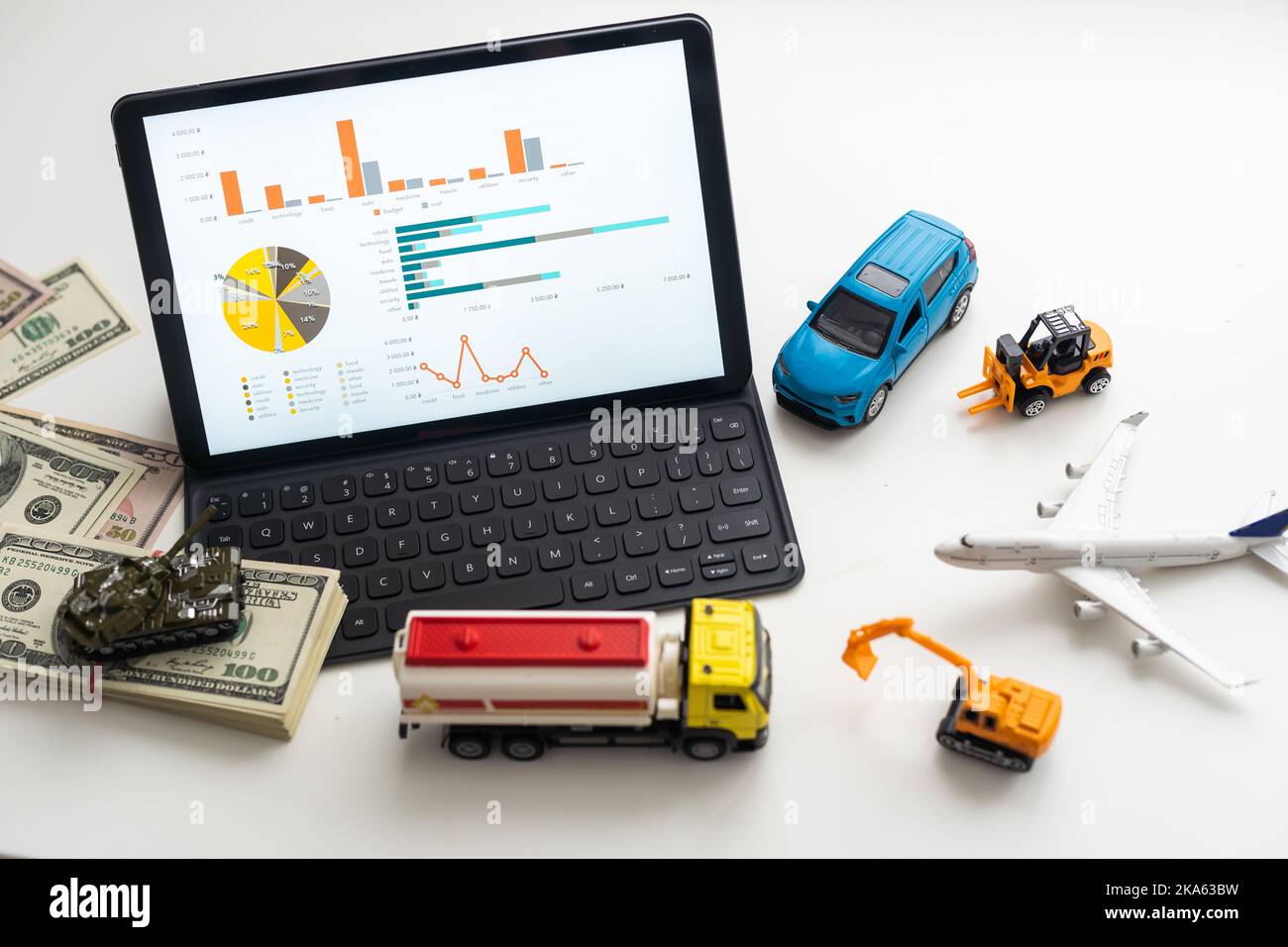 different types of toy cars and a tablet, money Stock Photo - Alamy