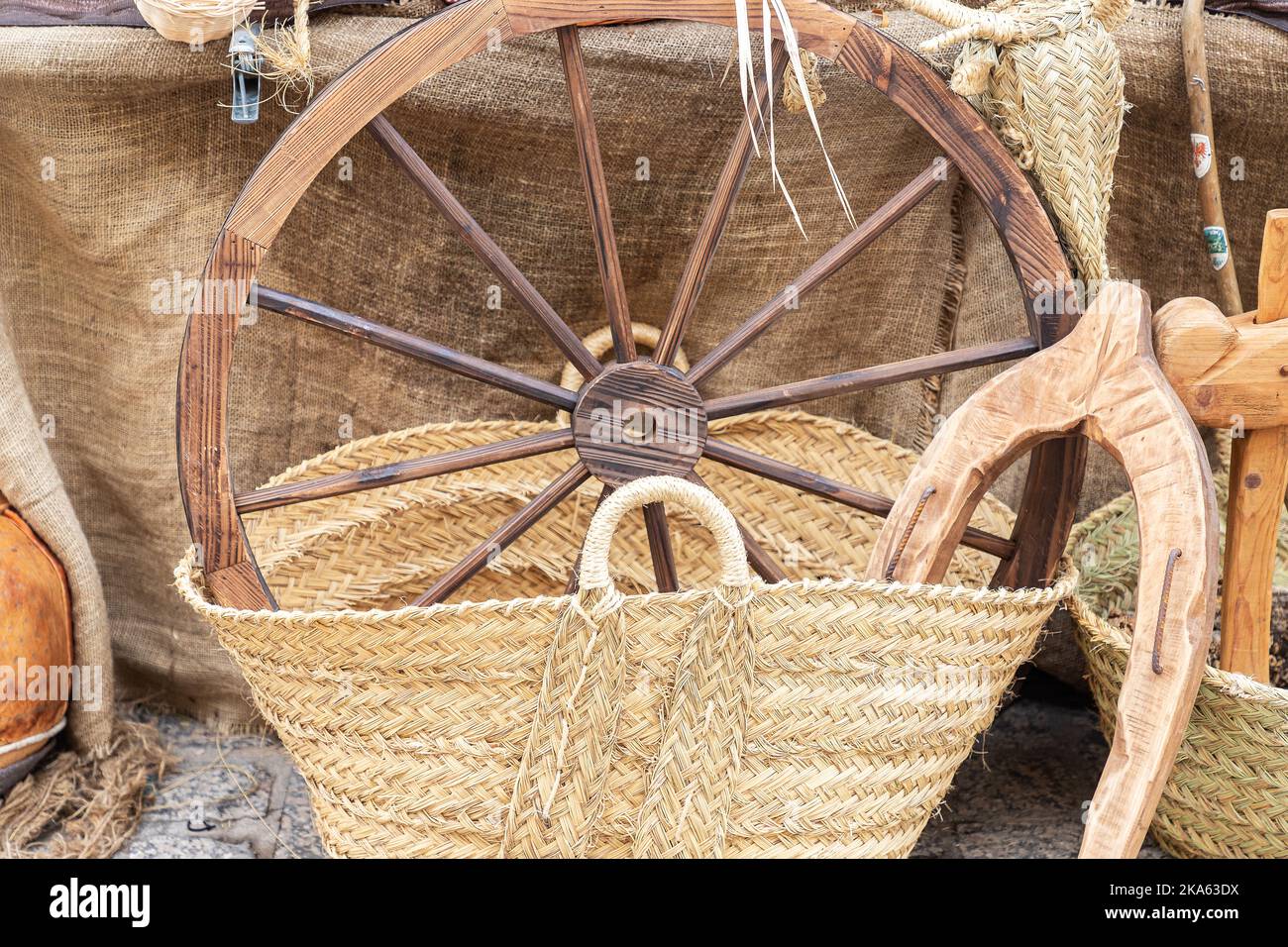 horizontal view in foreground of a wooden wheel inside a wicker basket ...