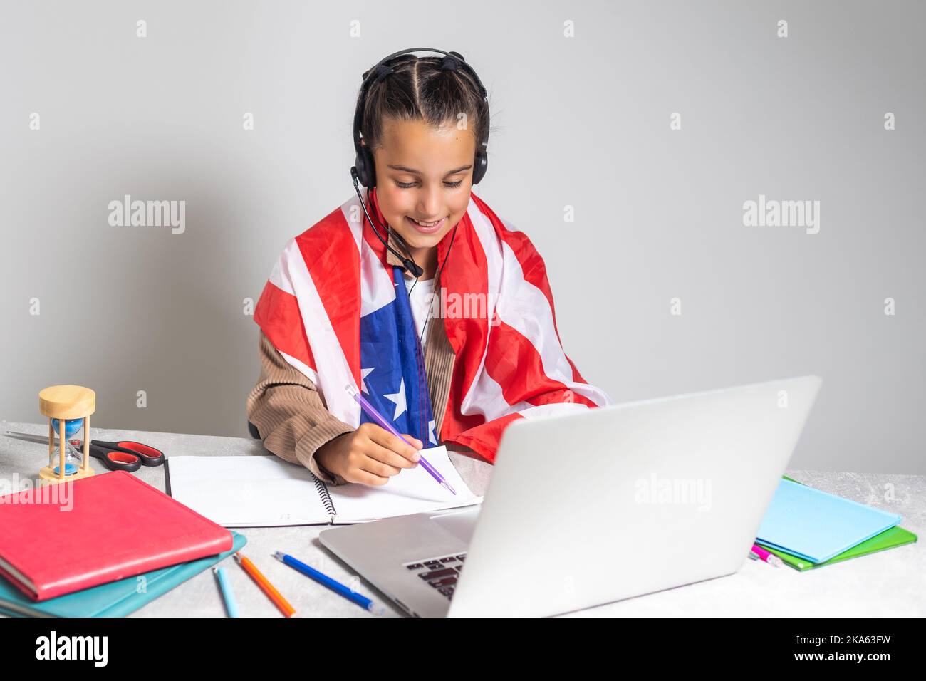 little girl cheering with American flag. Education online on laptop ...