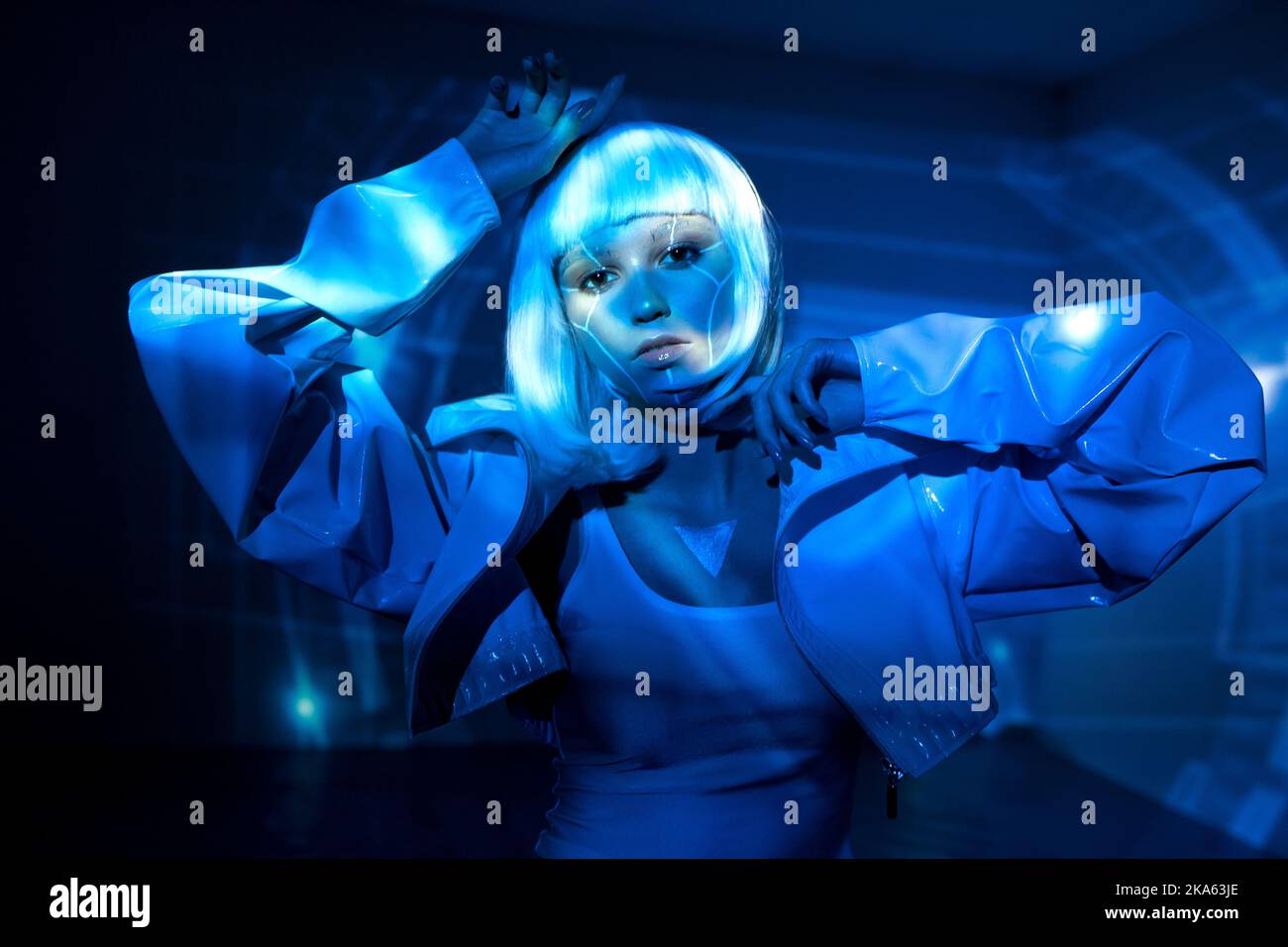 Robot woman in protective uniform stands and looks at camera on alert ...