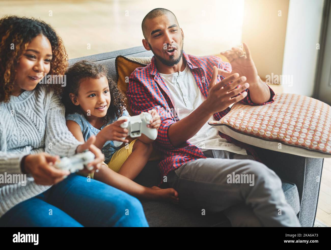 Playing their favourite family video game. an adorable little girl and ...
