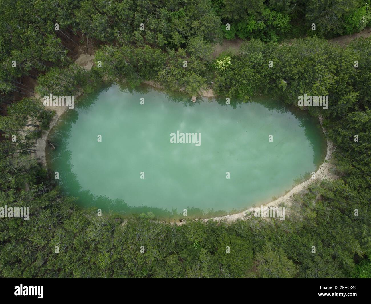 Aerial lake in forest. Top down view aerial flight over small lake of ...