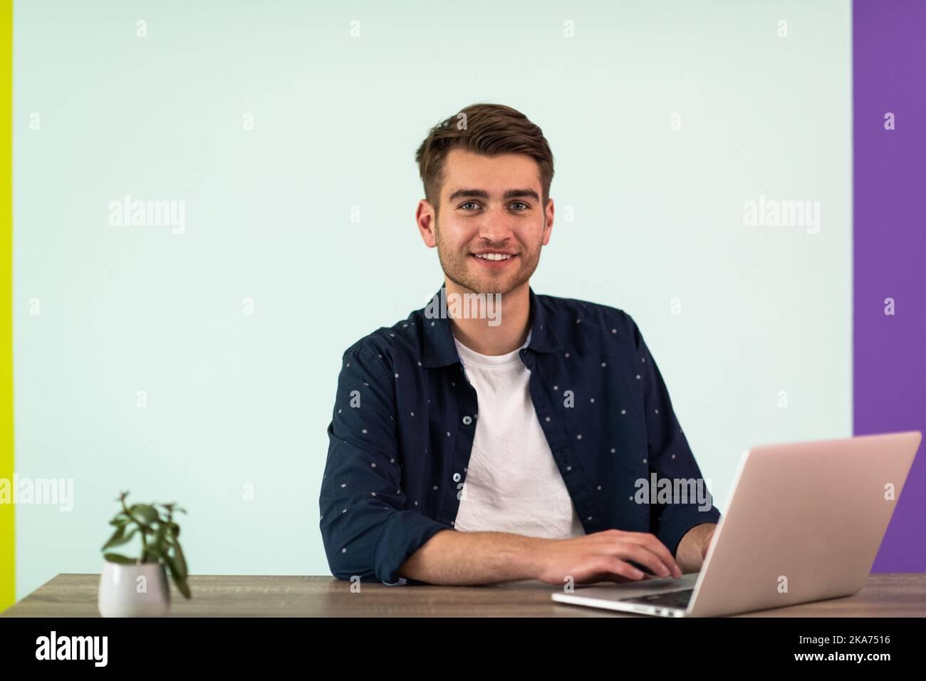 Smiling young man freelancer using laptop studying online working from ...
