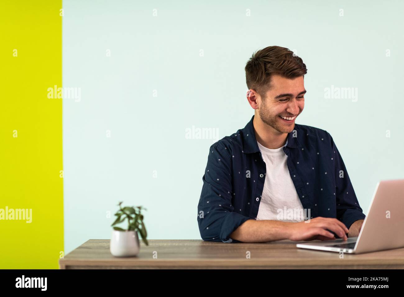 Smiling young man freelancer using laptop studying online working from ...
