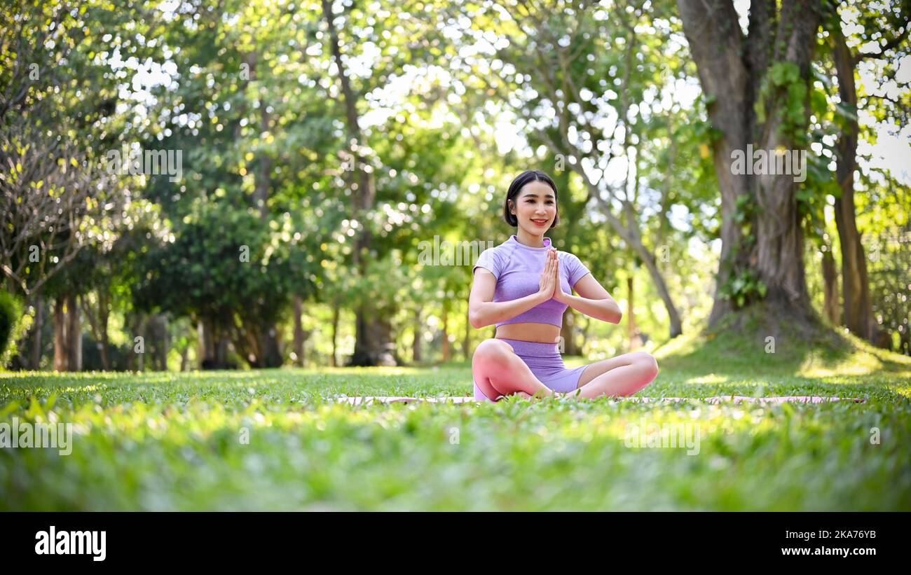 Happy and charming young Asian woman in sportswear controlling her ...