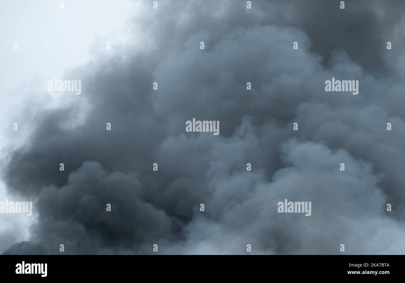A cloud of black smoke from a fire in a building materials warehouse ...