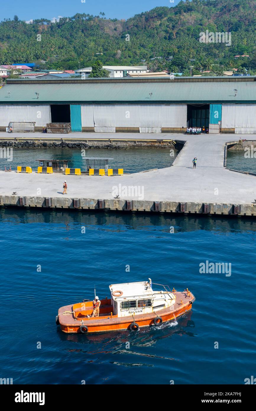 Man standing on back of orange port tender ready to receive mooring ...