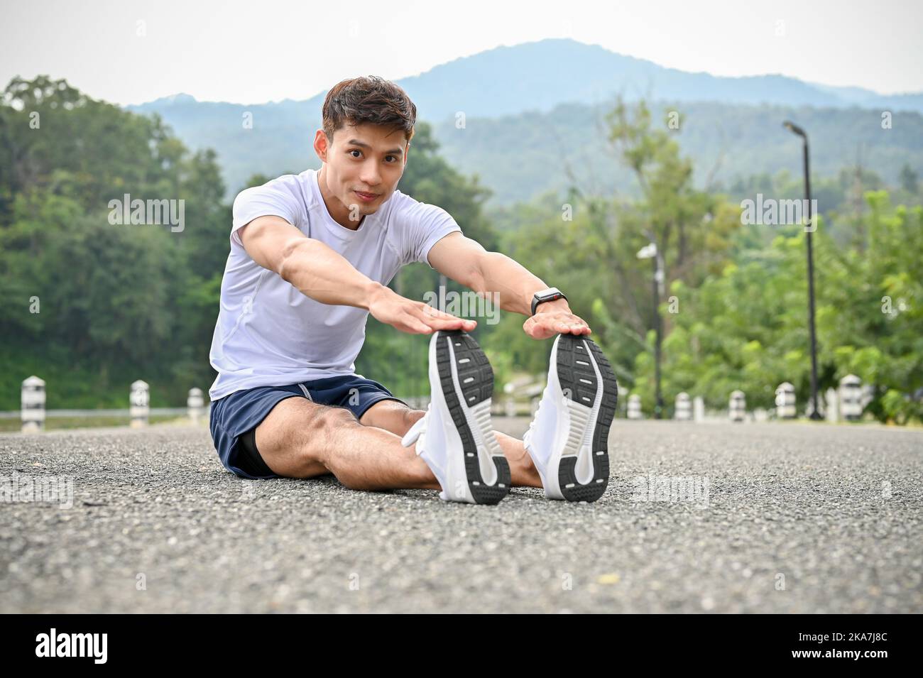 Active and handsome Asian athletic man in sportswear and running shoes ...