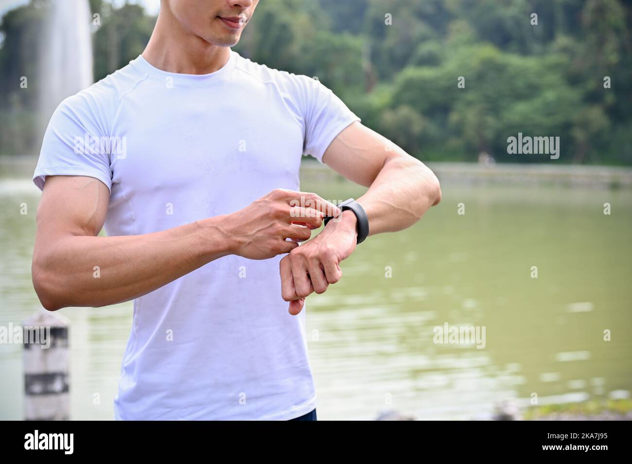 Handsome and athletic young Asian man in sportswear looking at his ...