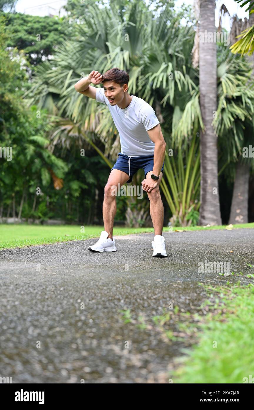 Active fit and handsome young Asian man in sportswear sweating and ...