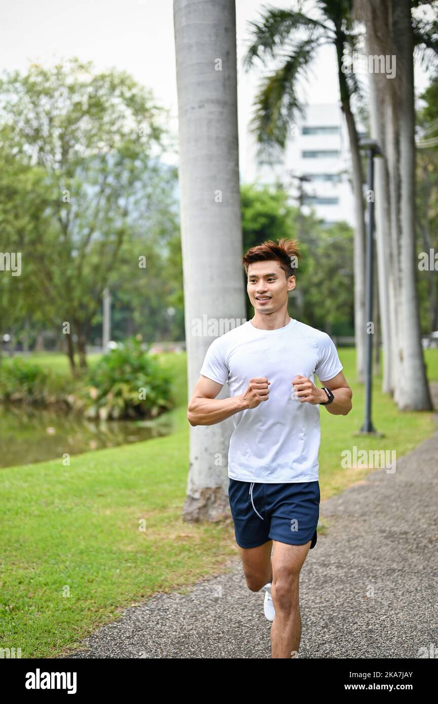 Portrait, Sporty millennial Asian athletic man in sportswear running or ...