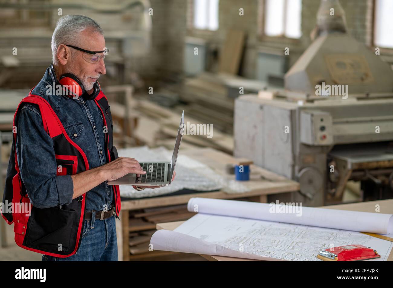 Craft person in reflective vest searching for information on internet ...
