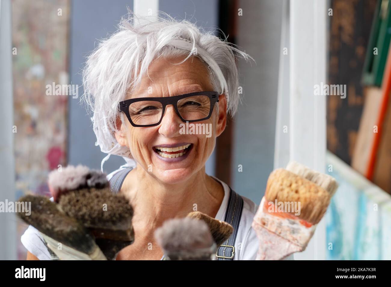 smiling happy older woman portrait, proud artist, in her fifties with ...