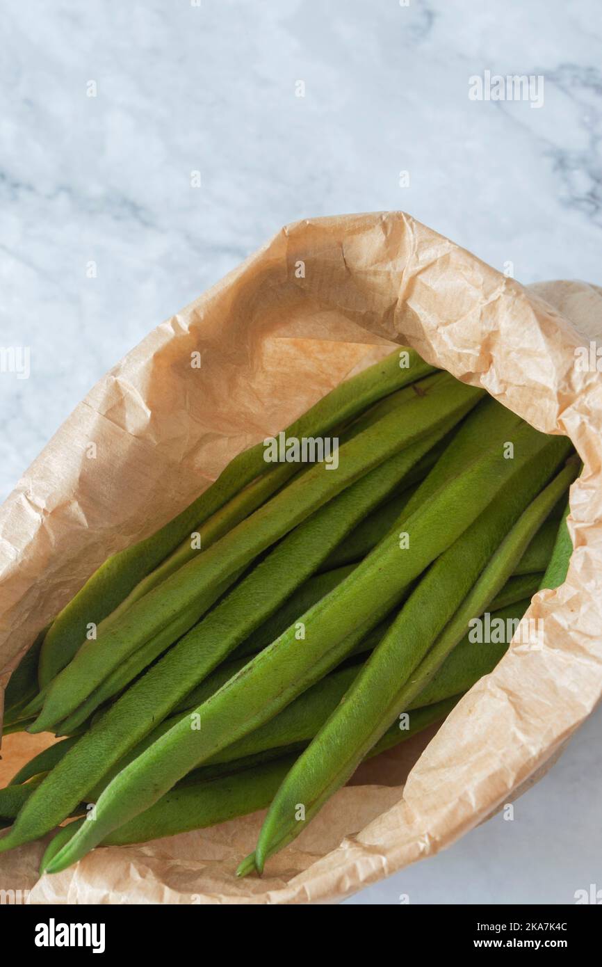Raw green beans in a brown paper bag. Eco friendly recycling packaging ...