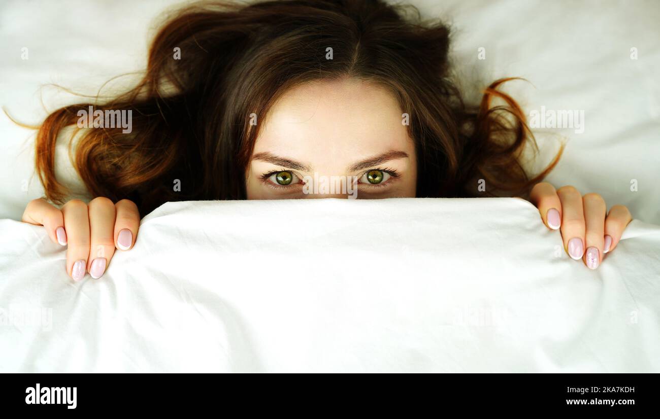 Woman in bed covered her face with blanket. Concept of insomnia or fear ...