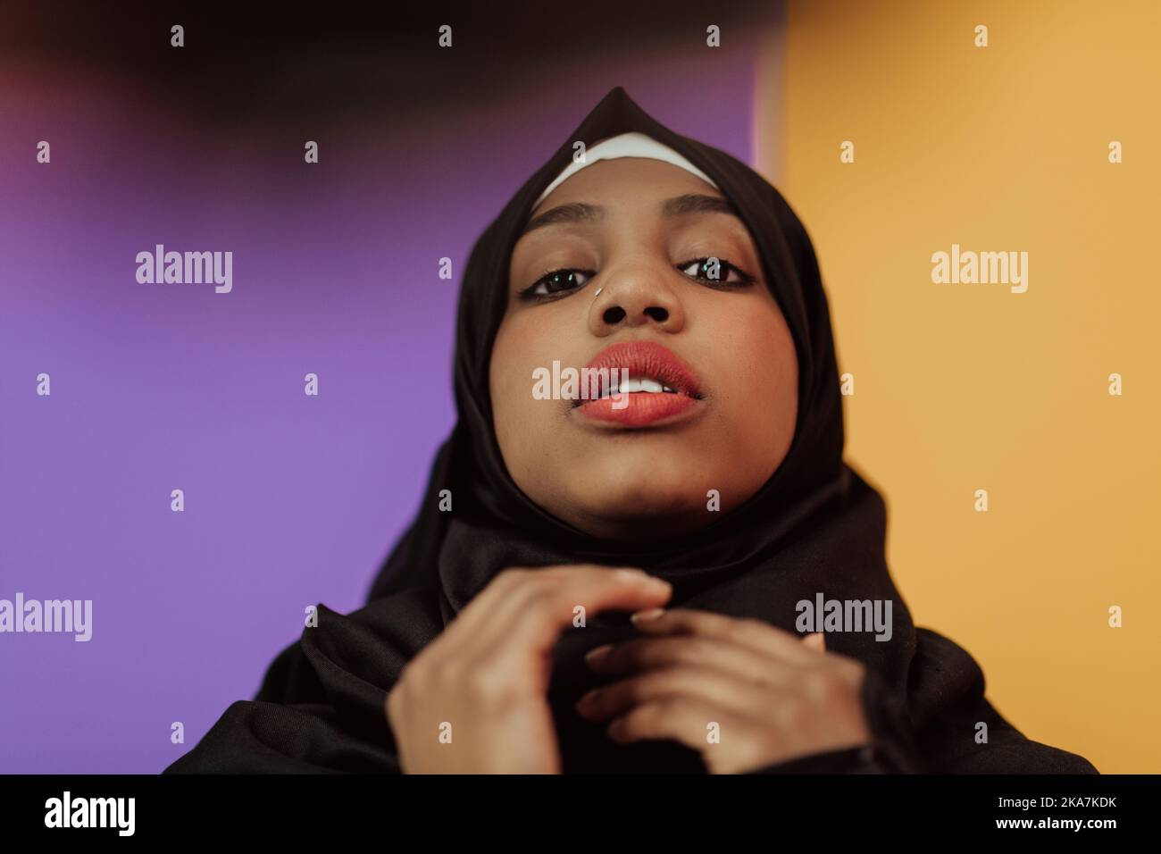 Muslim woman with a beautiful smile wearing a hijab poses in the studio ...