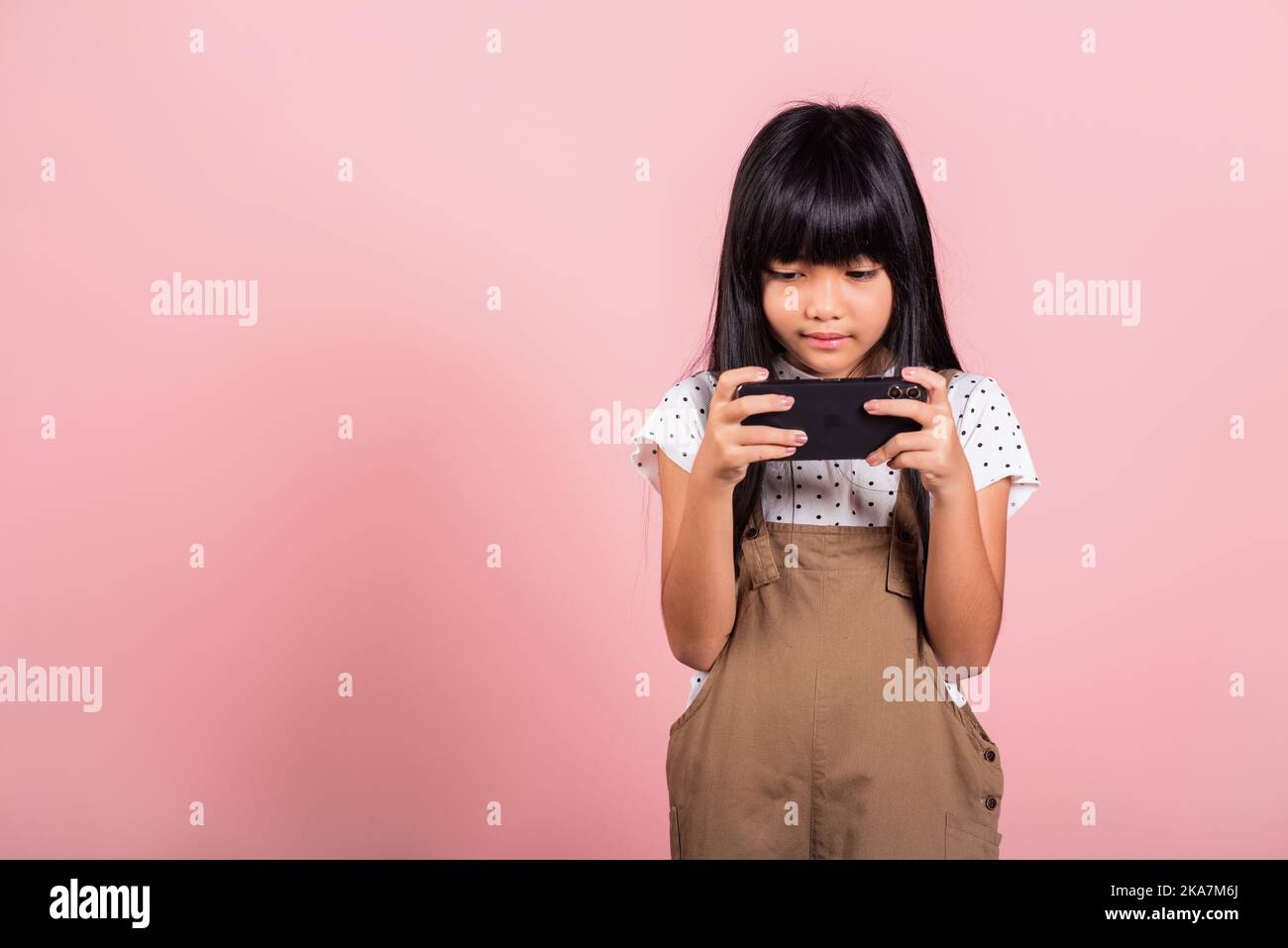 Asian kid 10 years enjoying using mobile phone for social network media ...